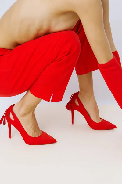 Fashion unrecognizable model in red pants and shoes. Minimalist elegant ...