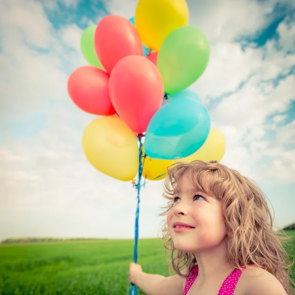 Child with balloons in spring field Stock Photo by ©Yaruta 70631361