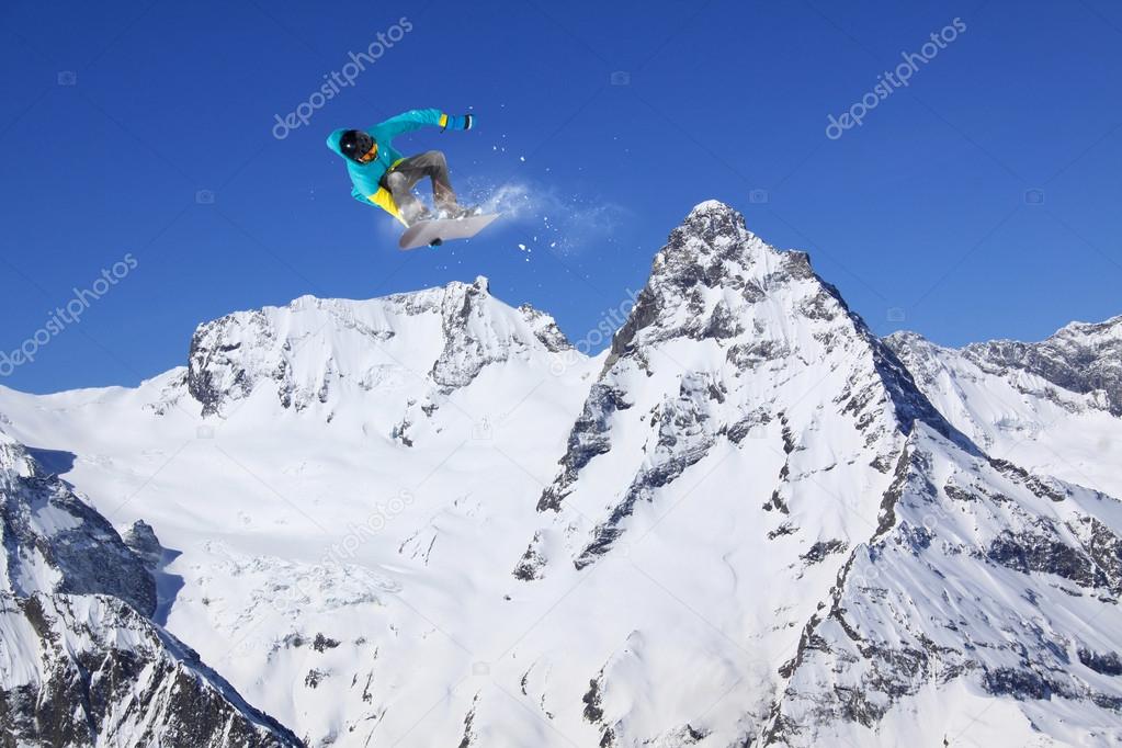 Snowboard rider jumping on mountains. Extreme snowboard freeride sport ...