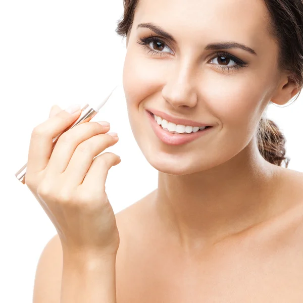 Smiling woman applying concealer on face, isolated Stock Photo by ©g ...