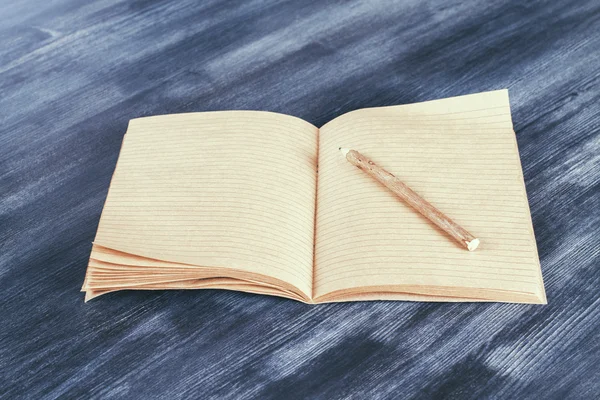 Old copybook and pencil on dark wooden desktop Stock Photo by ©peshkova ...