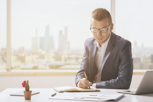 Young man writing in notepad - Stock Image - Everypixel