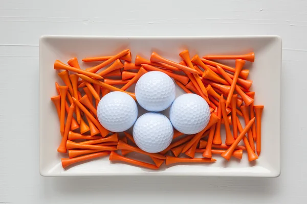 White ceramic dishes with golf balls and wooden tees Stock Photo by ...