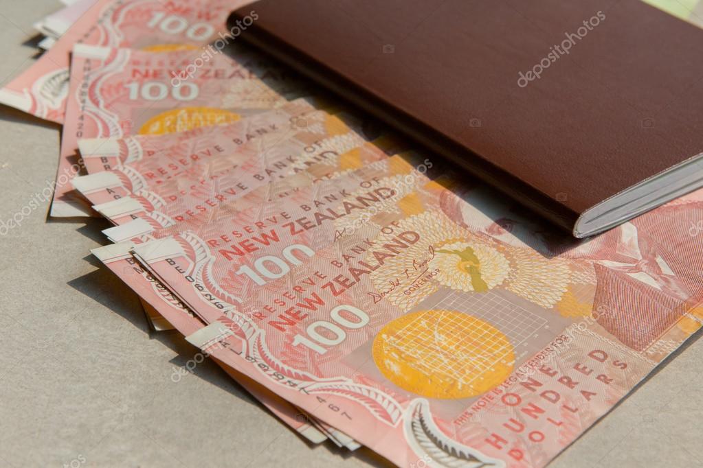 Stack of new zealand 100 dollars bank note and red cover persona ...