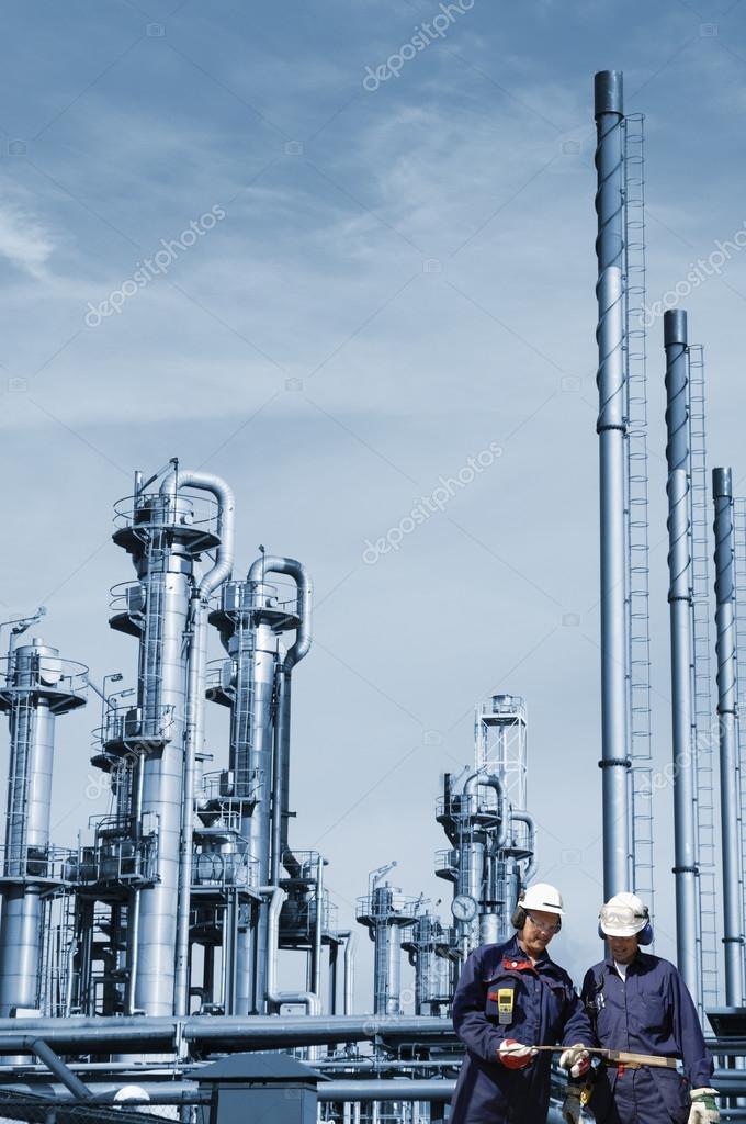 Oil workers with industrial refinery Stock Photo by ©lagereek 80451482
