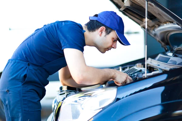 Angry mechanic smashing car engine Stock Photo by ©minervastock 67067507