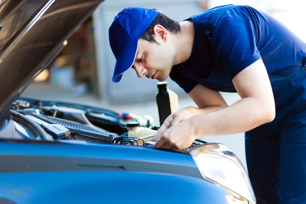 Angry mechanic smashing car engine Stock Photo by ©minervastock 67067507