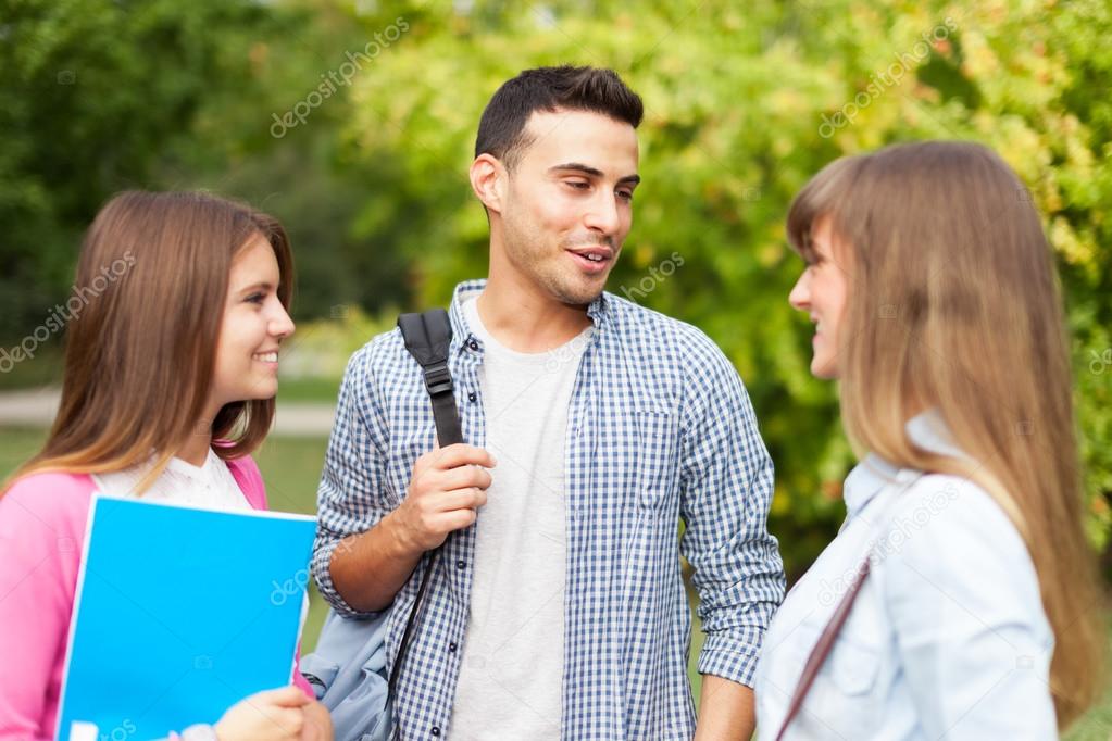 Three students talking in park Stock Photo by ©minervastock 82309660