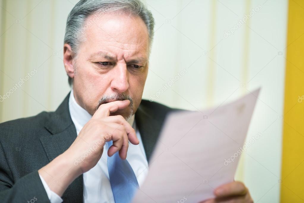 Businessman reading a document — Stock Photo © minervastock #90822752 Businessman reading a document — Stock Photo © minervastock #90822752