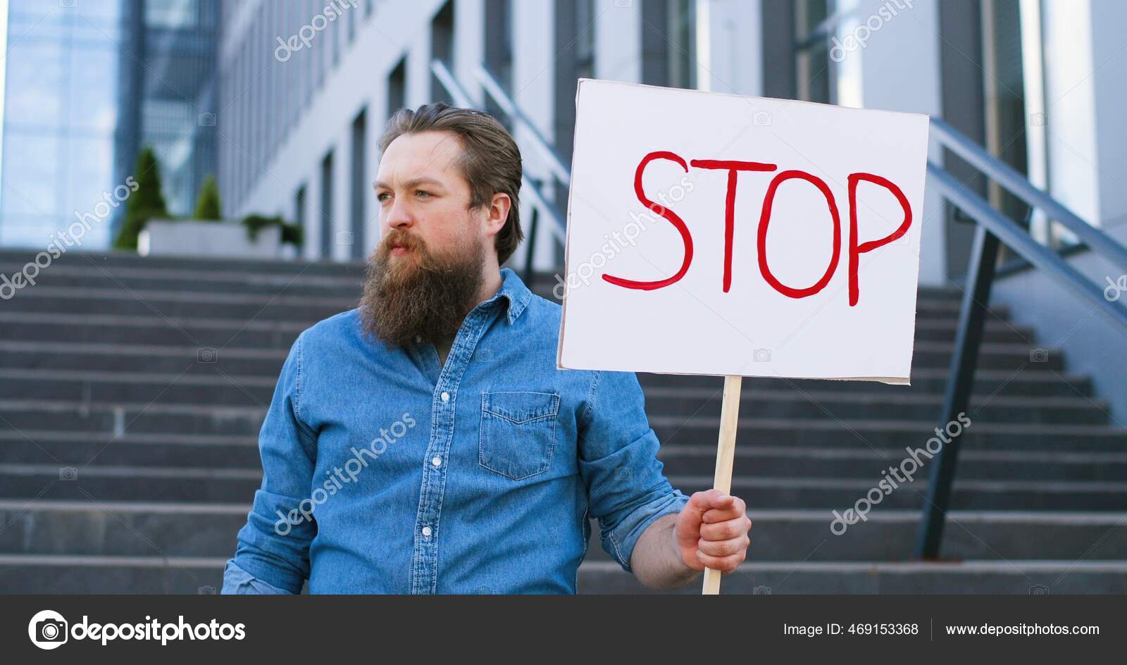 Portrait of Caucasian male activist with beard holding poster Stop at ...