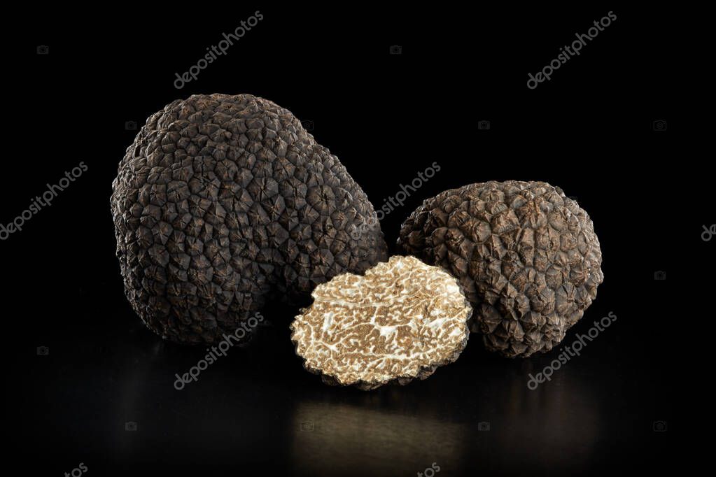 Grupo de trufas negras y rebanada en negro, camino de recorte incluido 2024