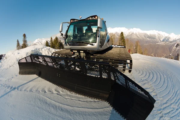 Snow-grooming machine on snow hill ready for skiing slope prepar ...