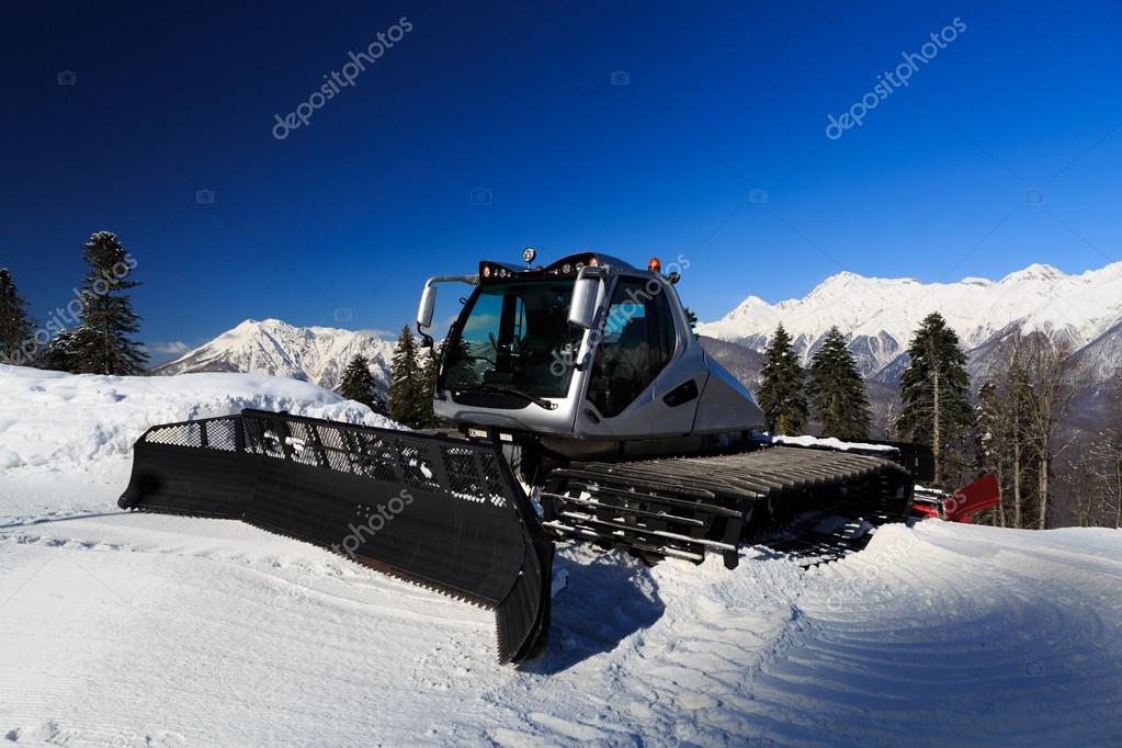 Snow-grooming machine on snow hill ready for skiing slope prepar ...