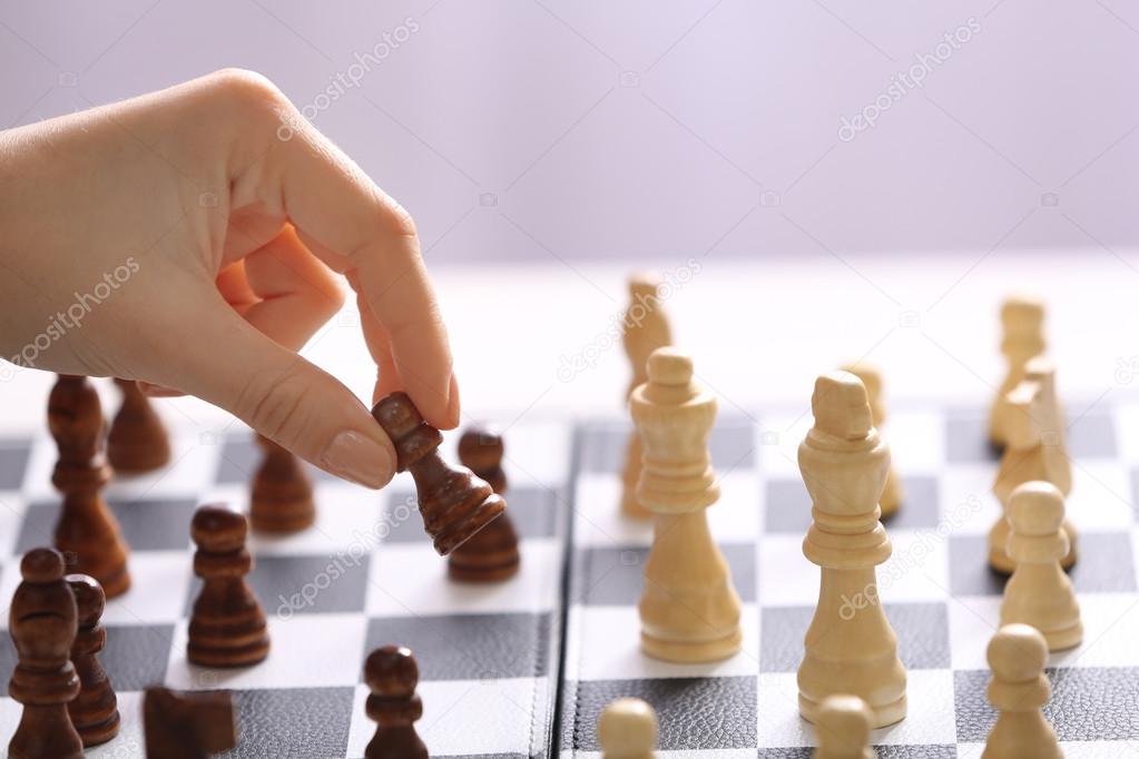 Female hand playing chess Stock Photo by ©belchonock 103412946