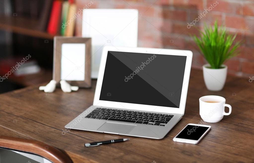 Workplace with laptop, mobile phone Stock Photo by ©belchonock 110367934