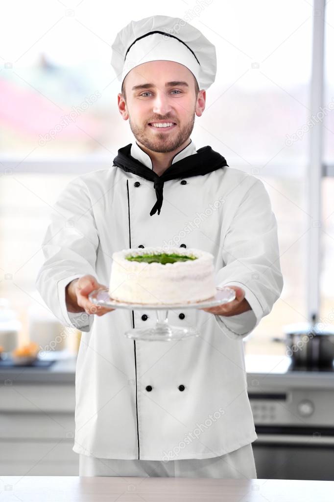 Male chef holding cake. — Stock Photo © belchonock #110368528