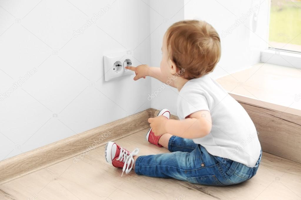 Baby playing with electrical outlet Stock Photo by ©belchonock 117021846