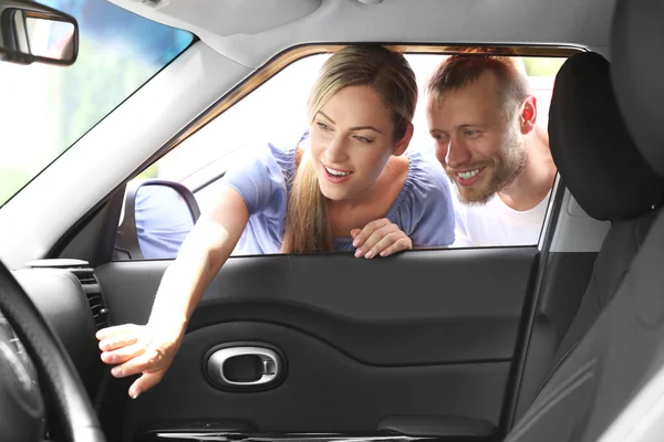 Young couple looking inside car - Stock Image - Everypixel