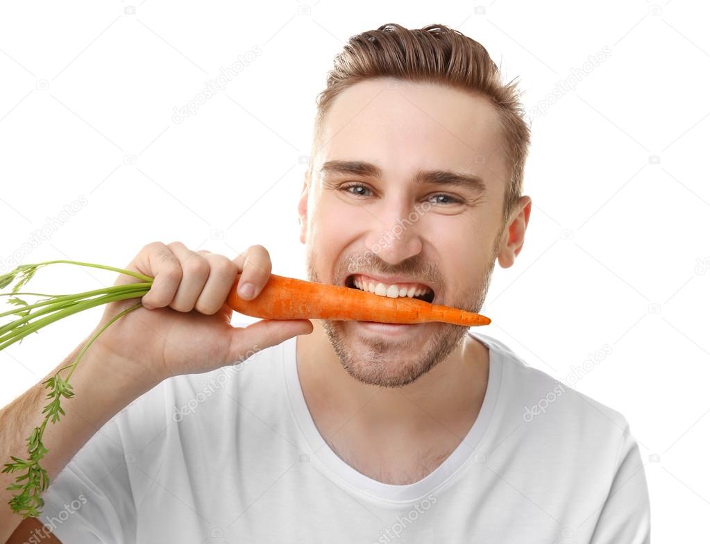 Handsome man eating carrot Stock Photo by ©belchonock 119855390