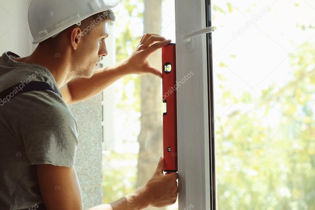 Construction worker installing window Stock Photo by ©belchonock 124362352