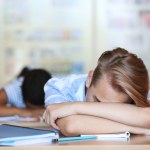 Tired schoolgirl in classroom Stock Photo by ©belchonock 124781056