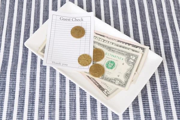Check and money on tray on table close-up - Stock Image - Everypixel