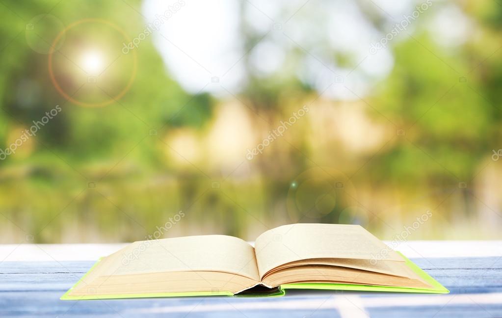 Open book on table outdoors Stock Photo by ©belchonock 52141771