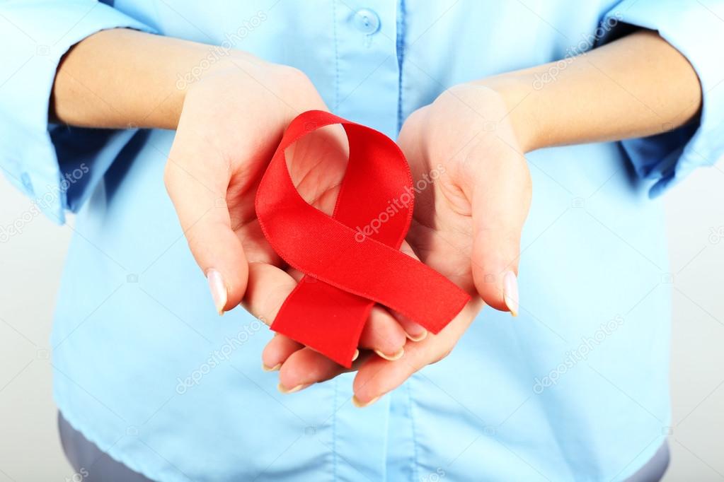 Woman holding red ribbon on light background — Stock Photo © belchonock ...
