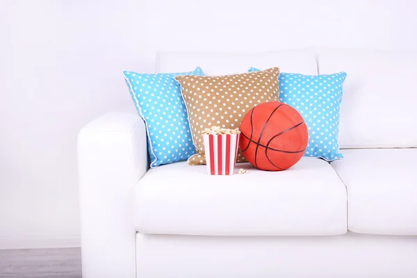 Popcorn and ball on sofa Stock Photo by ©belchonock 54032709