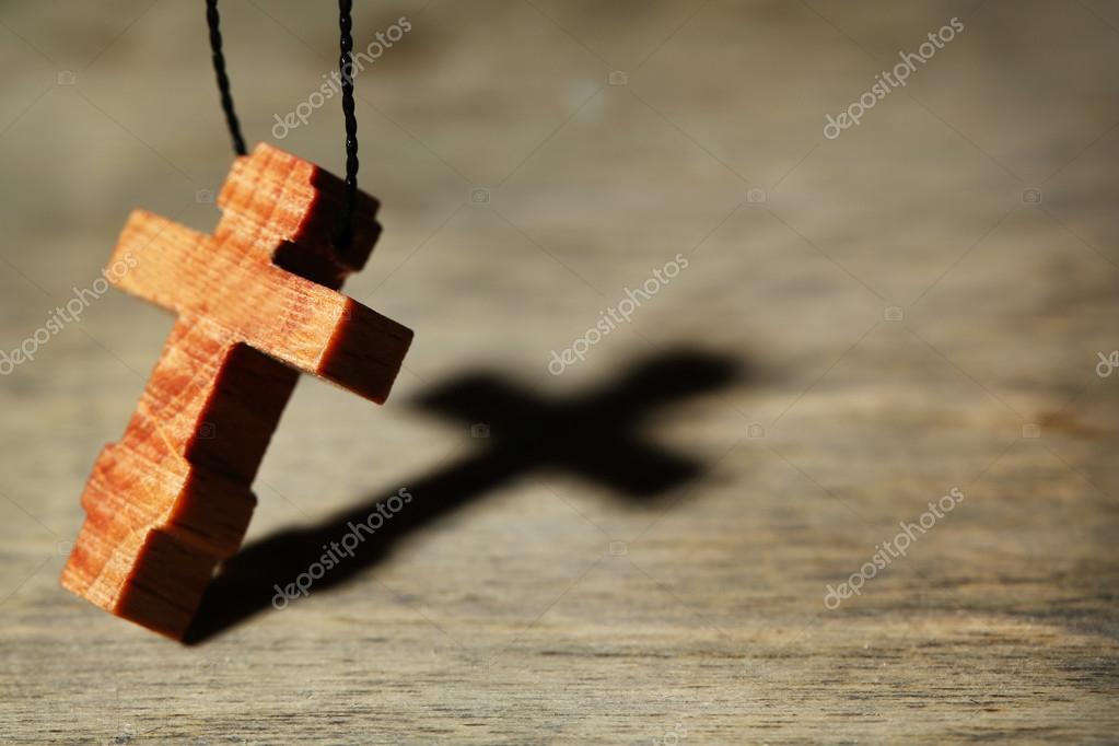 Wooden cross with deep shadow on wooden background Stock Photo by ...