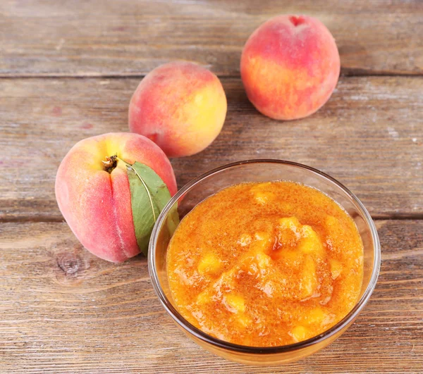 tasty peach jam with fresh peaches on wooden table - Stock Image ...