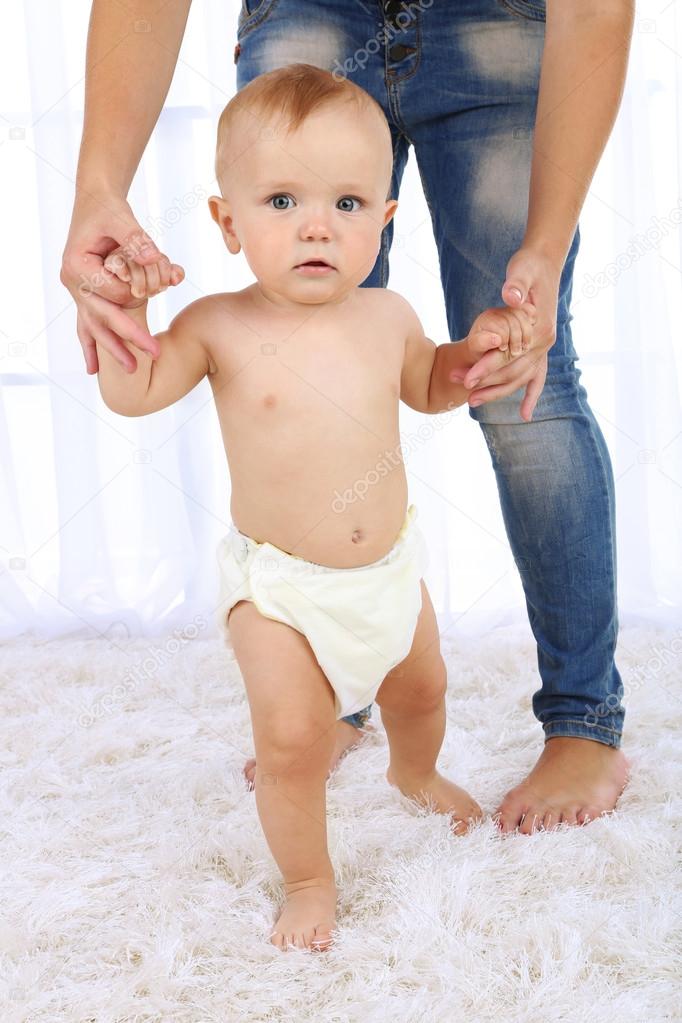 Baby boy taking first steps Stock Photo by ©belchonock 53865103