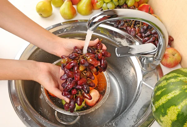 Woman's hands washing apple and other fruits in colander in sink Stock ...