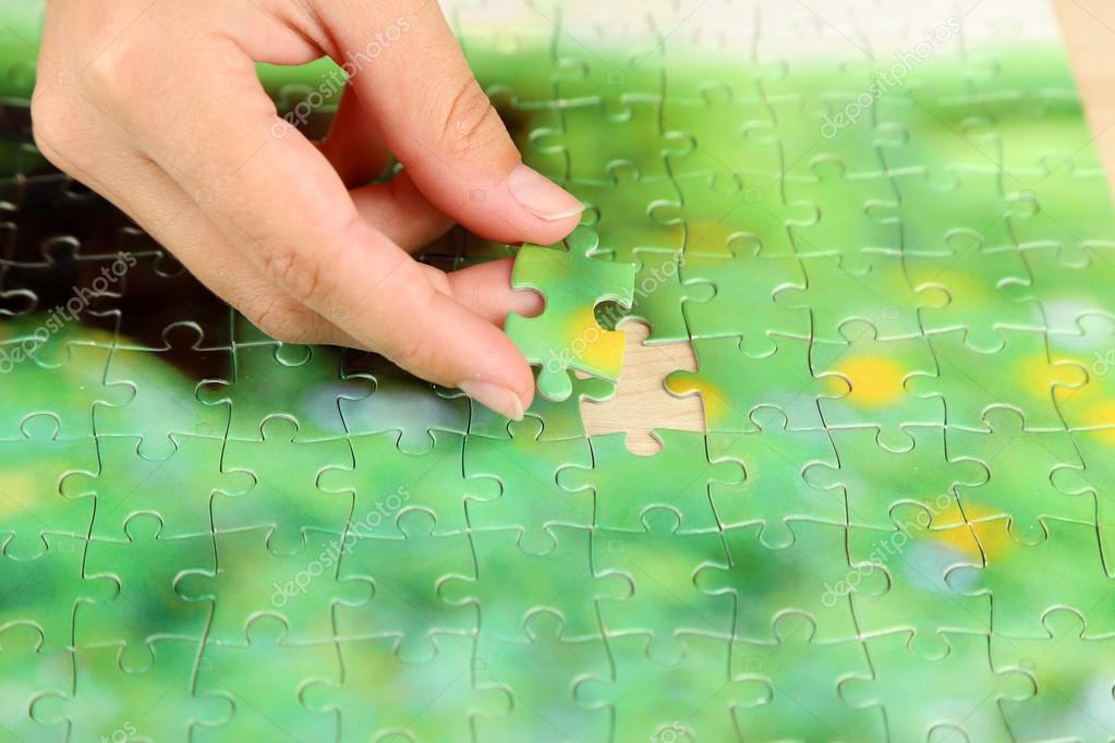 Hand holding puzzle piece Stock Photo by ©belchonock 54252115