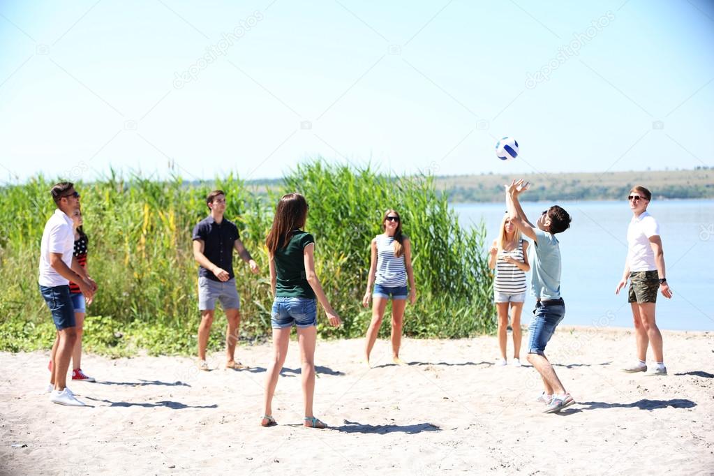 Young people playing volleyball on beach Stock Photo by ©belchonock ...