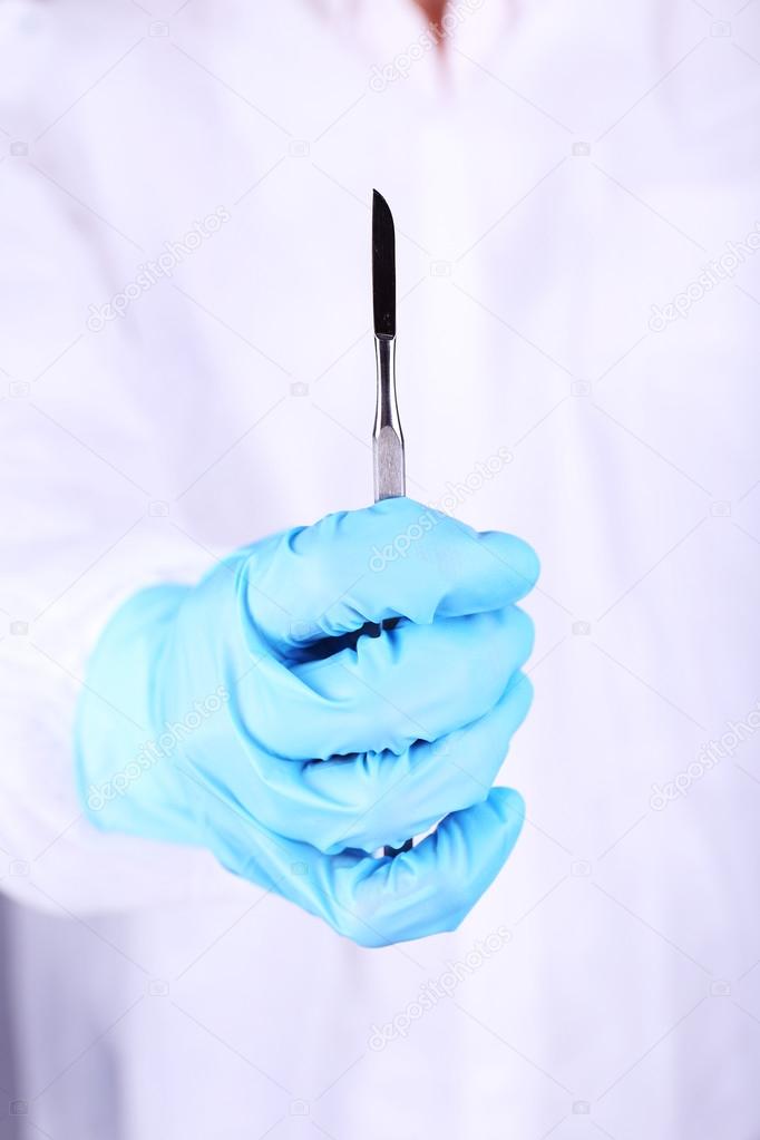 Surgeon's hand holding scalpel closeup — Stock Photo © belchonock #56138617