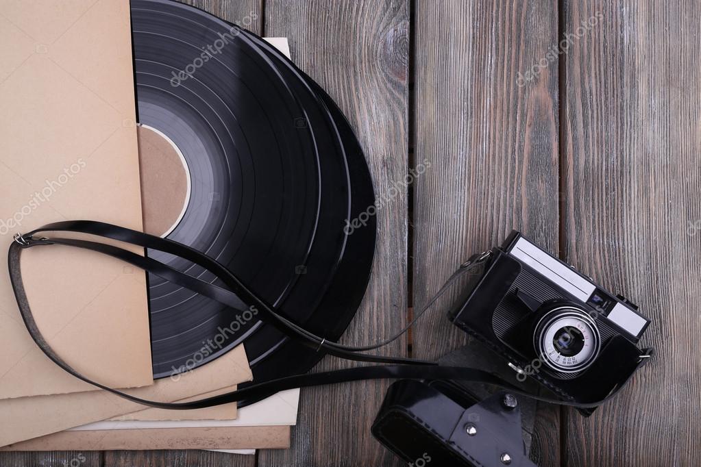 Vinyl records and paper covers and camera on wooden background Stock ...