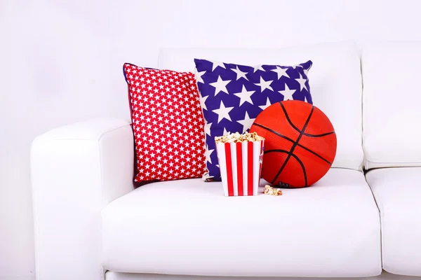 Popcorn and ball on sofa Stock Photo by ©belchonock 54032709