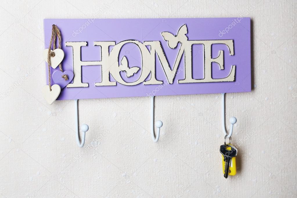 Key hanging from hook, on light wall background Stock Photo by ...