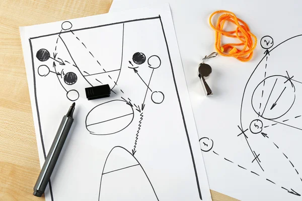 Scheme basketball game on sheet of paper and wooden table background ...