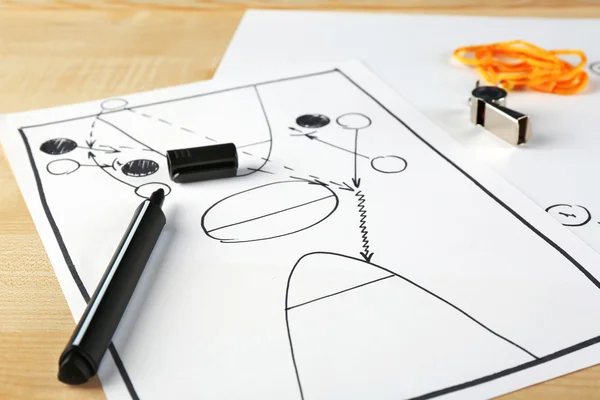 Scheme basketball game on sheet of paper and wooden table background ...