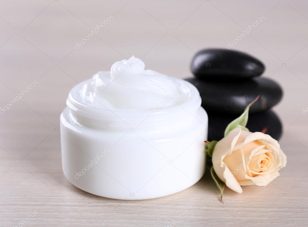 Cosmetic cream with spa stones Stock Photo by ©belchonock 64665903