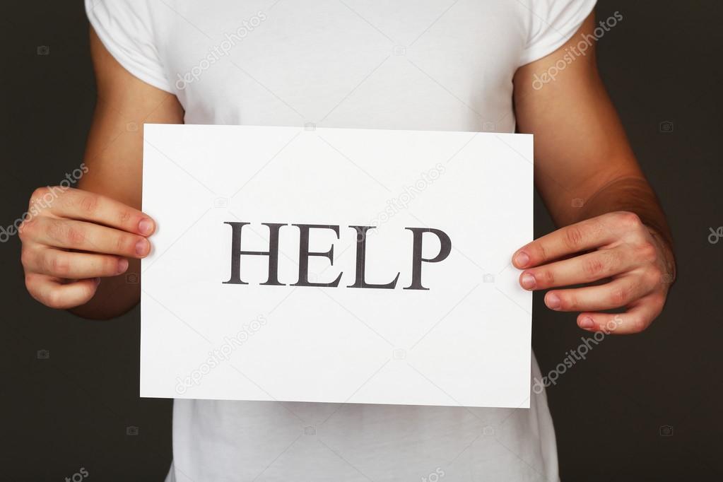 Sheet of paper with Help sign in male hand on dark background Stock ...