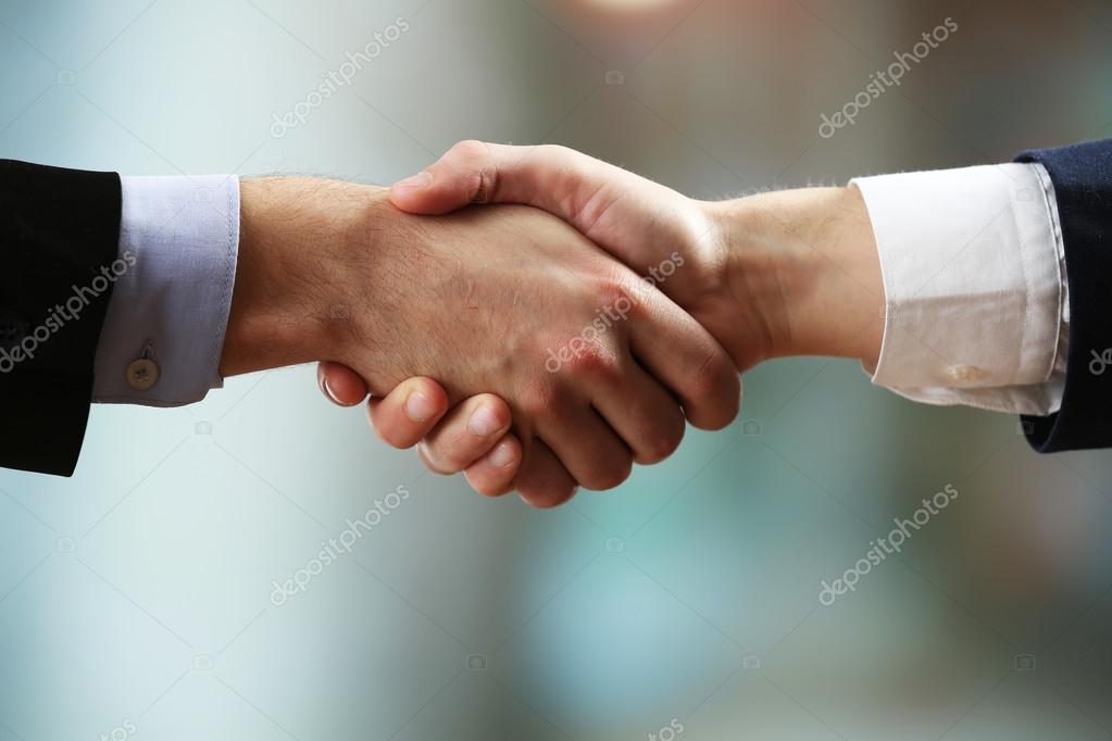 Business handshake on bright background Stock Photo by ©belchonock 65406143