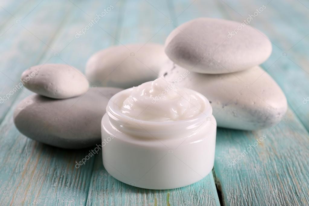 Cosmetic cream with spa stones on wooden background Stock Photo by ...