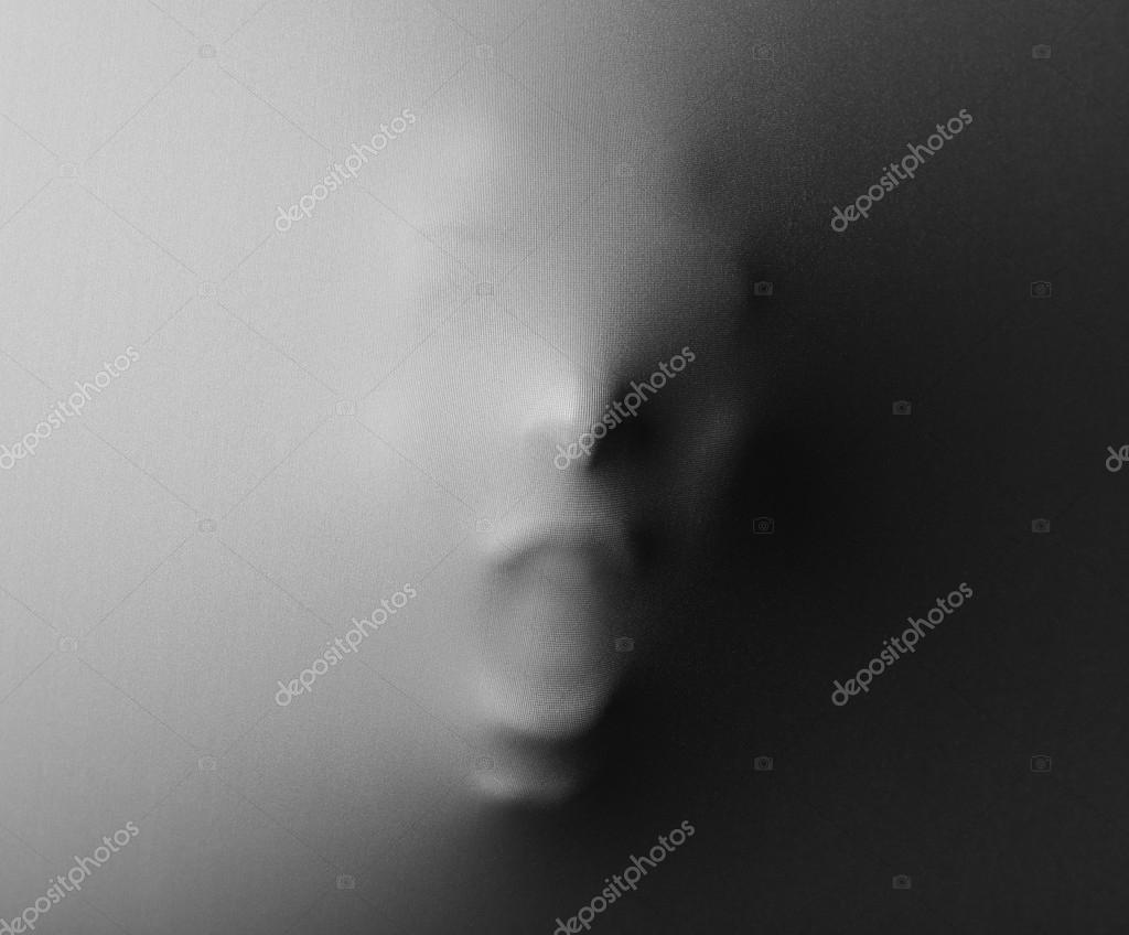 Screaming human face pressing through fabric as horror background Stock ...