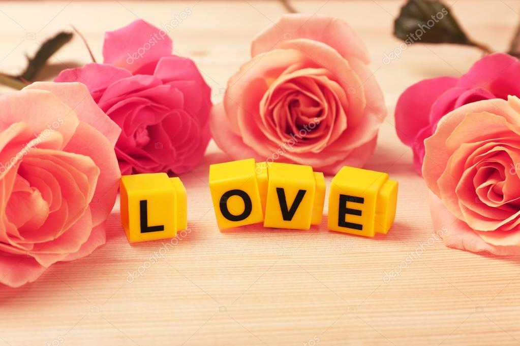 Beautiful roses with word LOVE on wooden background Stock Photo by ...