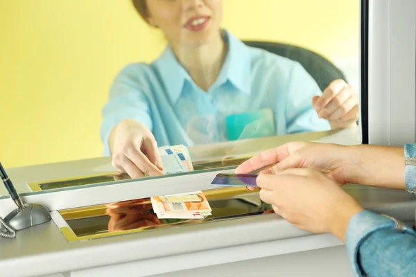 Teller window with working cashier Stock Photo by ©belchonock 68729049