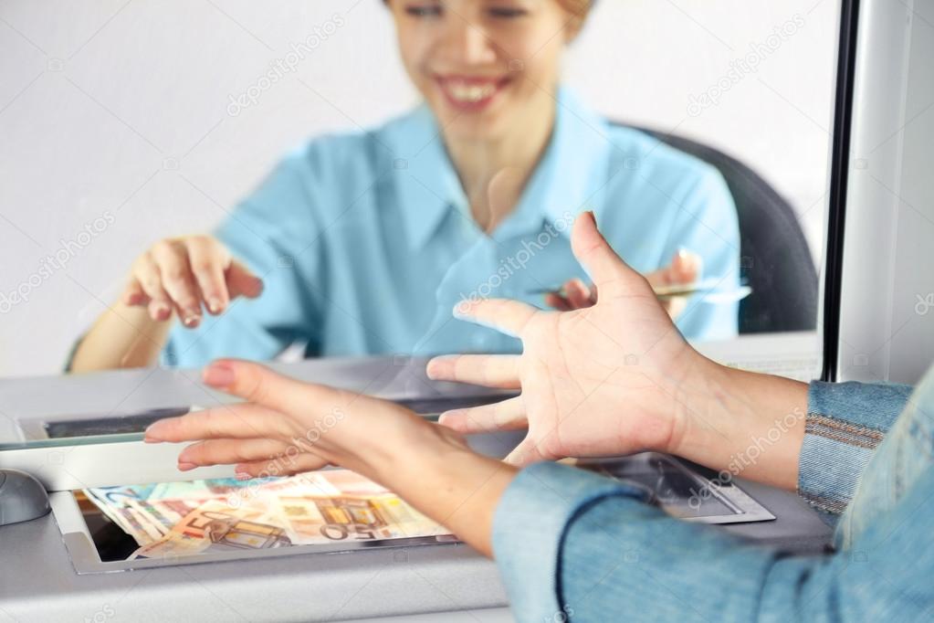 Teller window with working cashier Stock Photo by ©belchonock 68729049