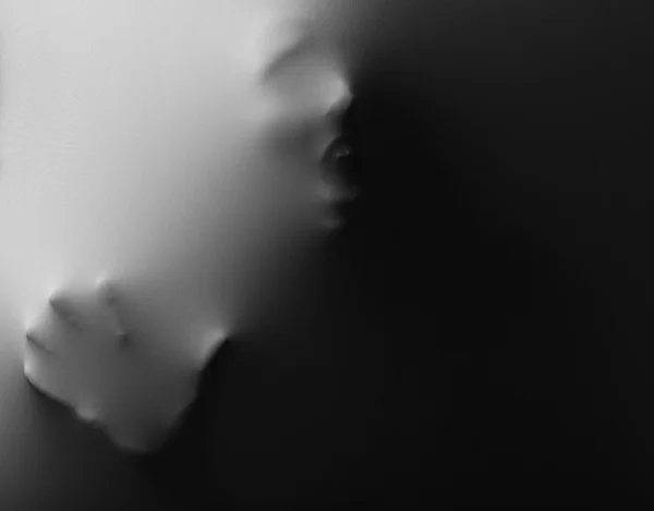 Screaming human face with hands pressing through fabric as horror ...